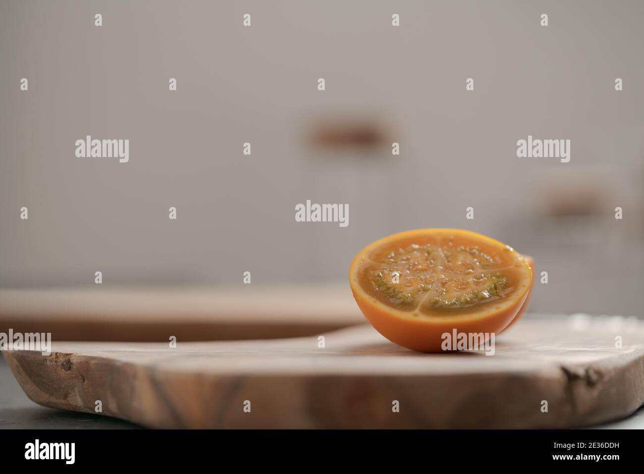Lulo fruit sliced in halves on olive wood board on kitchen countertop ...