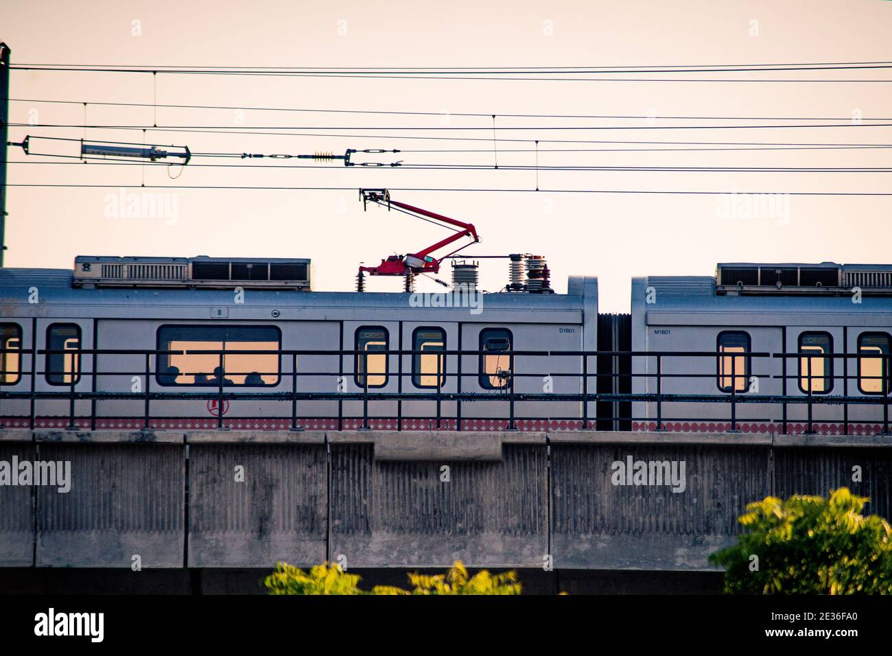 Aerial dusk shots of metro train on elevated bridge with people visible ...