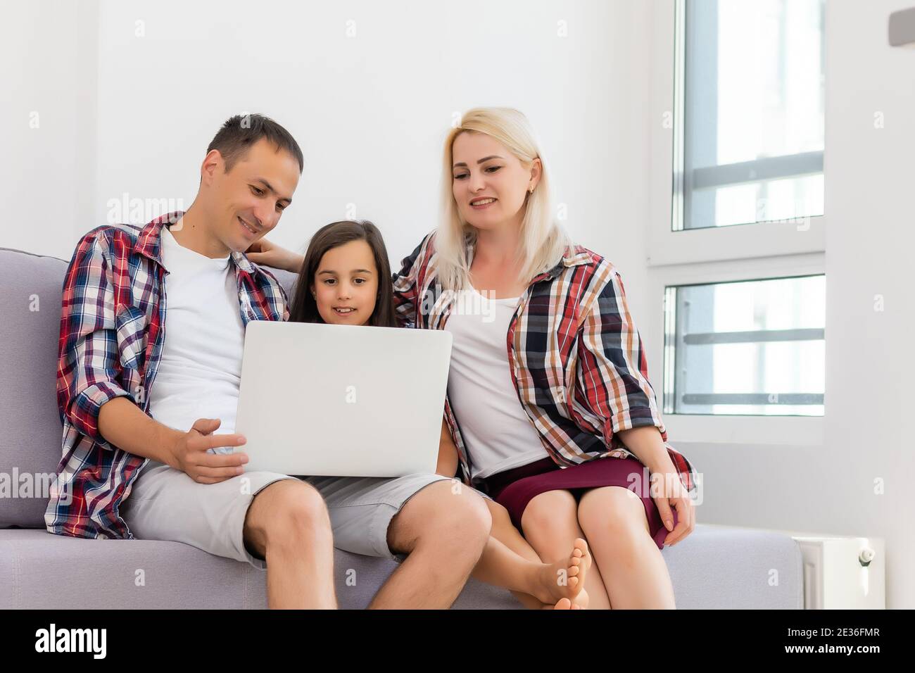 Smiling young parents and their child are very happy, they are at home ...