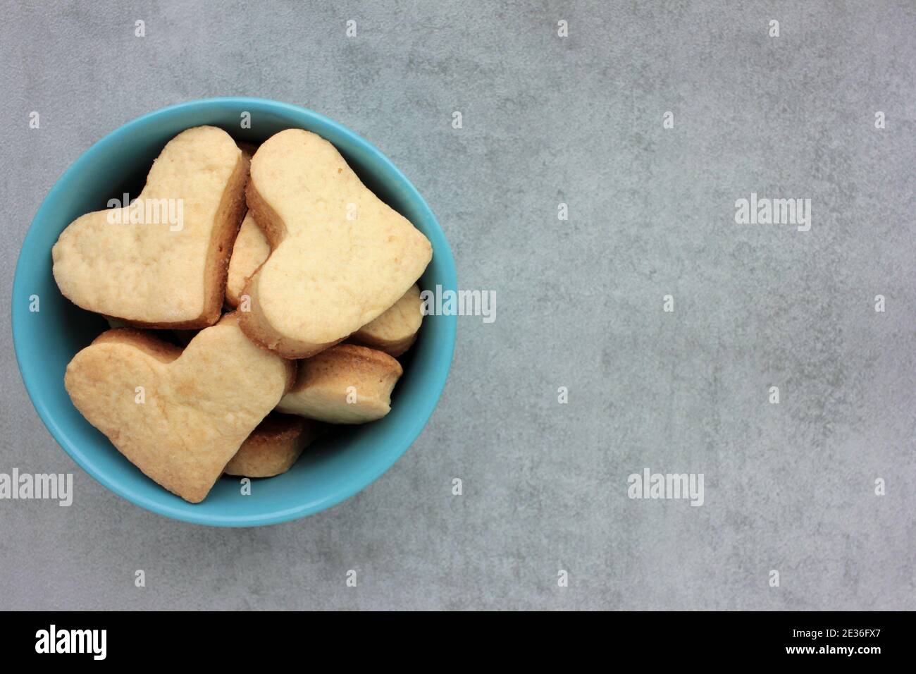Heart shaped cookies in blue bowl on grate concrete background ...