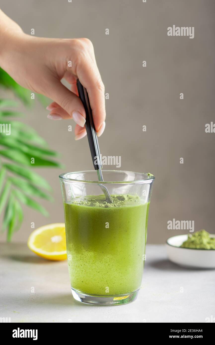 woman mixing water with green superfood powder Stock Photo - Alamy