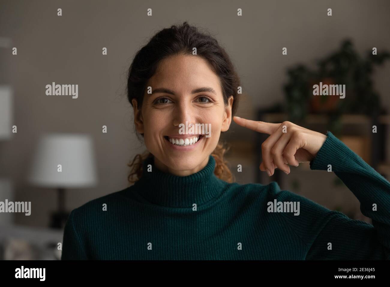 Portrait of smiling woman show point at face Stock Photo - Alamy