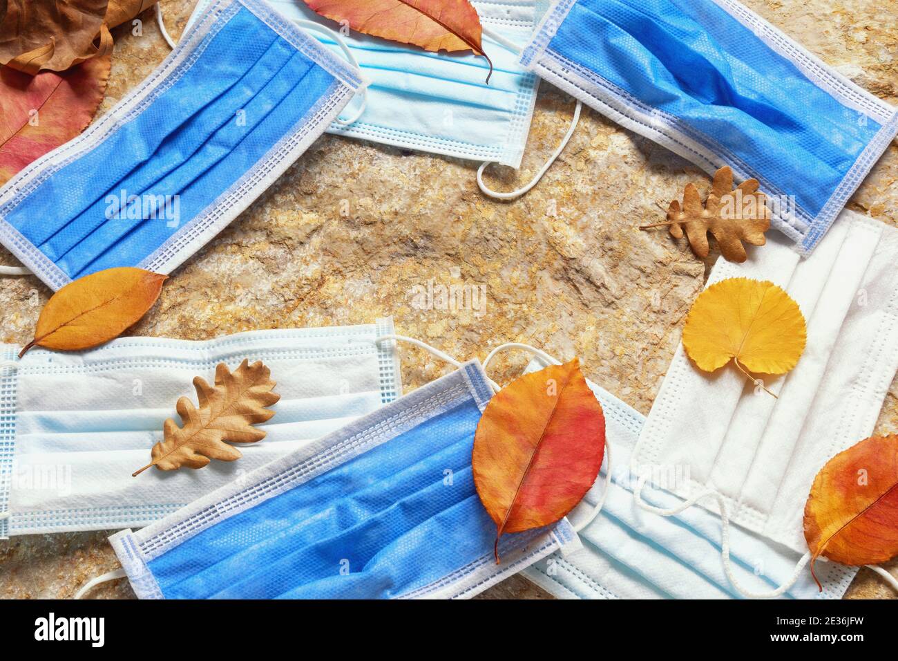 Old discarded medical protective face masks on stone among autumn ...