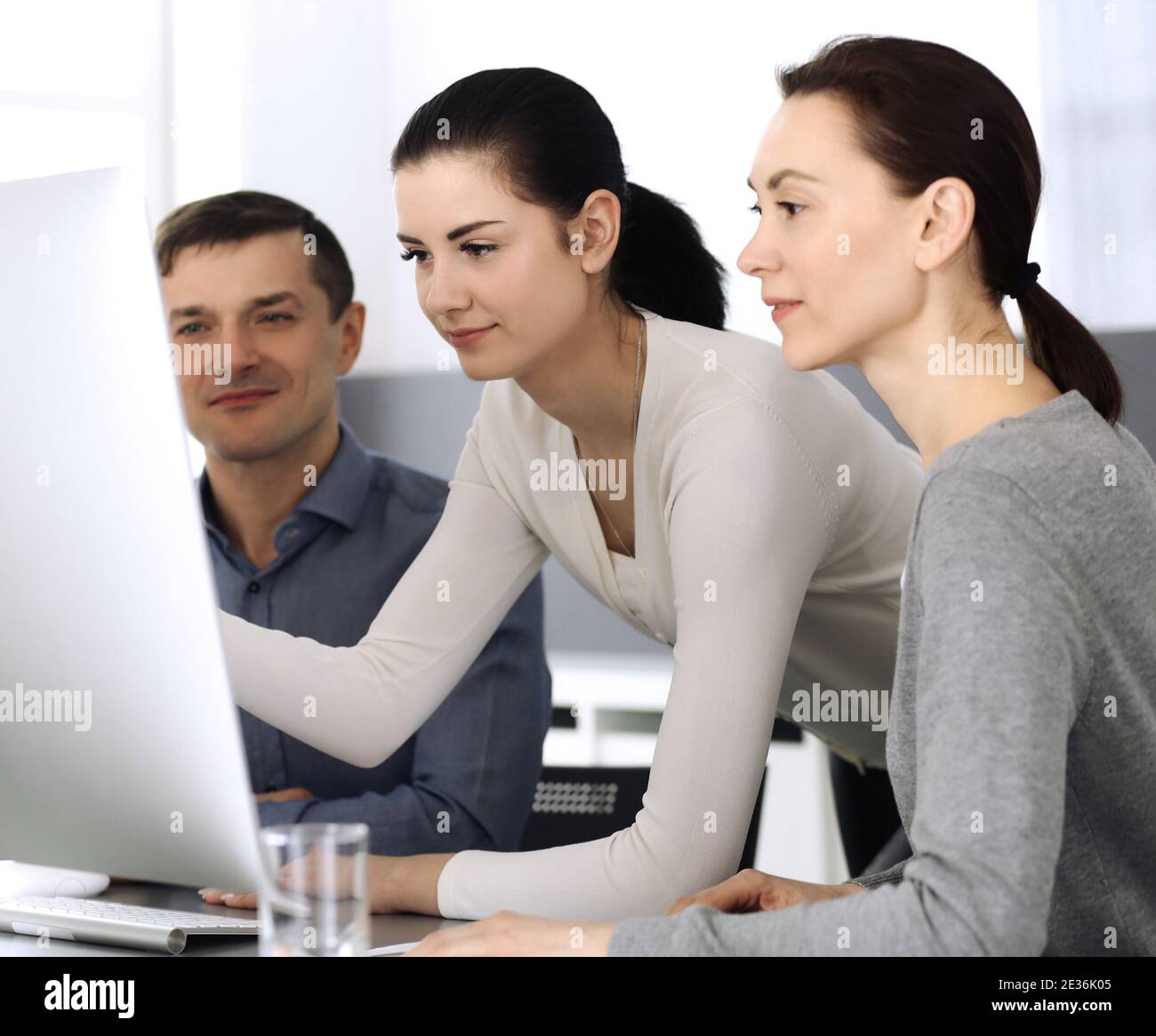 Group of business people discussing questions at meeting in modern ...