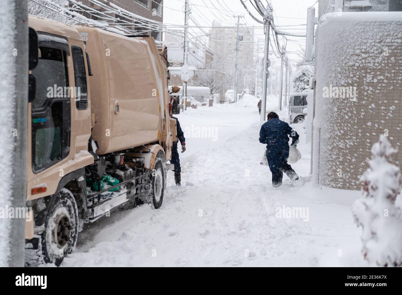 Waste collectors working in a hard winter conditions. Power lines ...