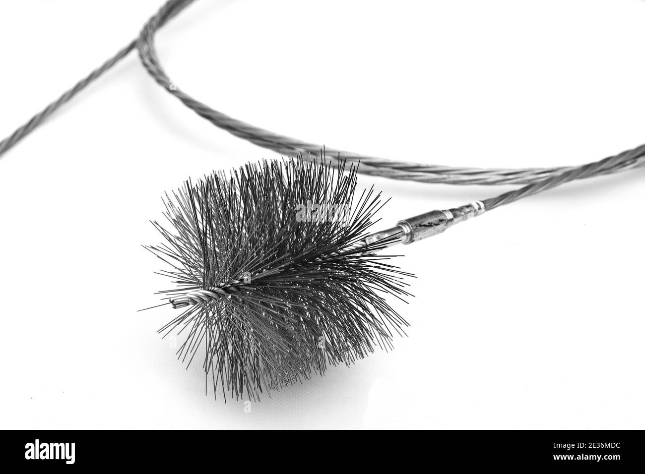 A chimney metal brush with steel cable isolated over a white background ...
