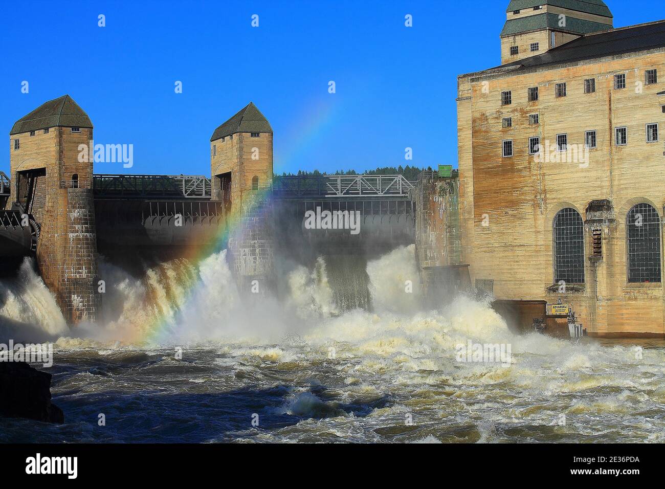 Water flowing over flood gates of a dam Stock Photo - Alamy