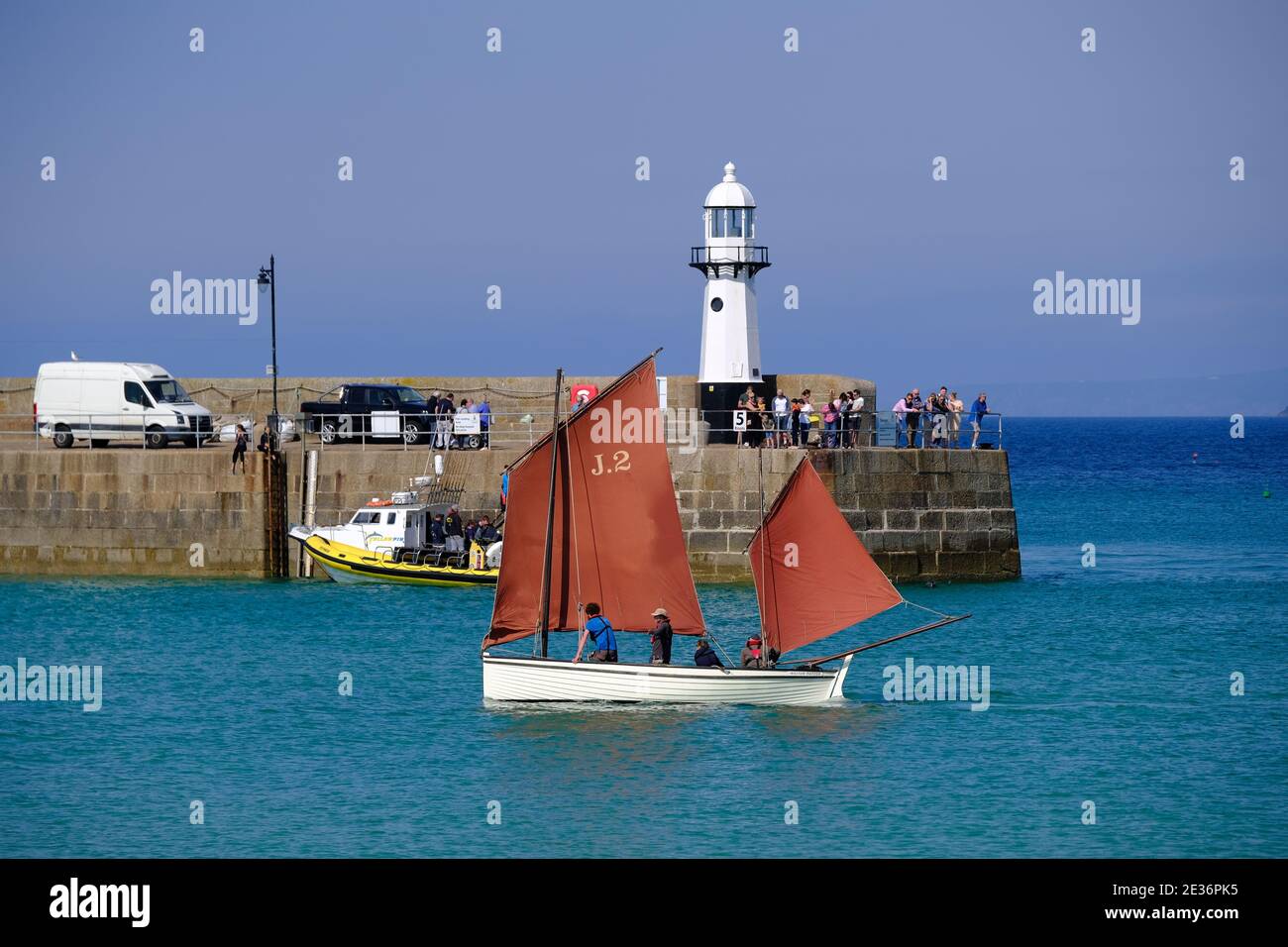 Traditional Cornish red sail boat in the harbout at St Ives in Cornwall ...