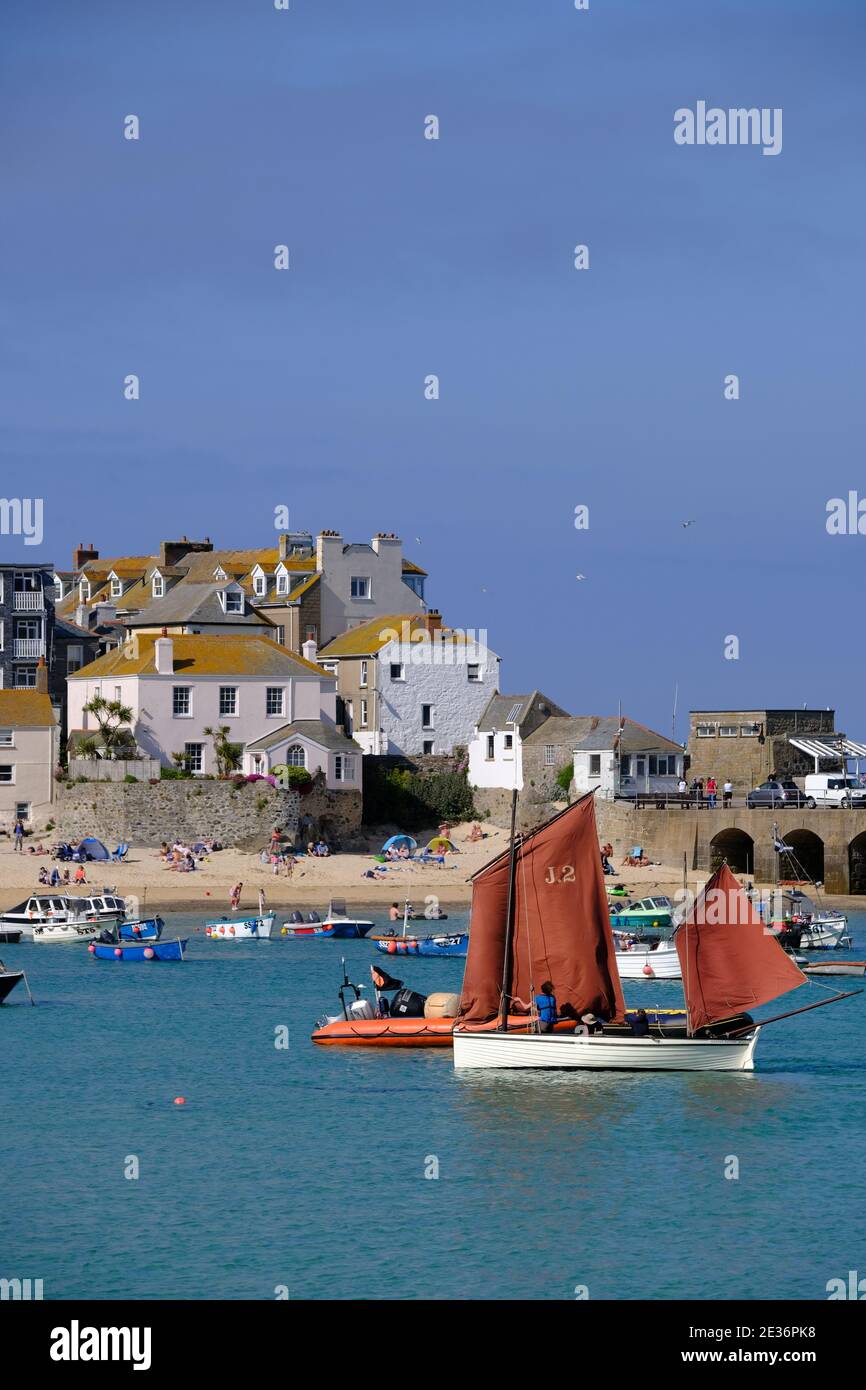 Traditional Cornish red sail boat in the harbout at St Ives in Cornwall ...