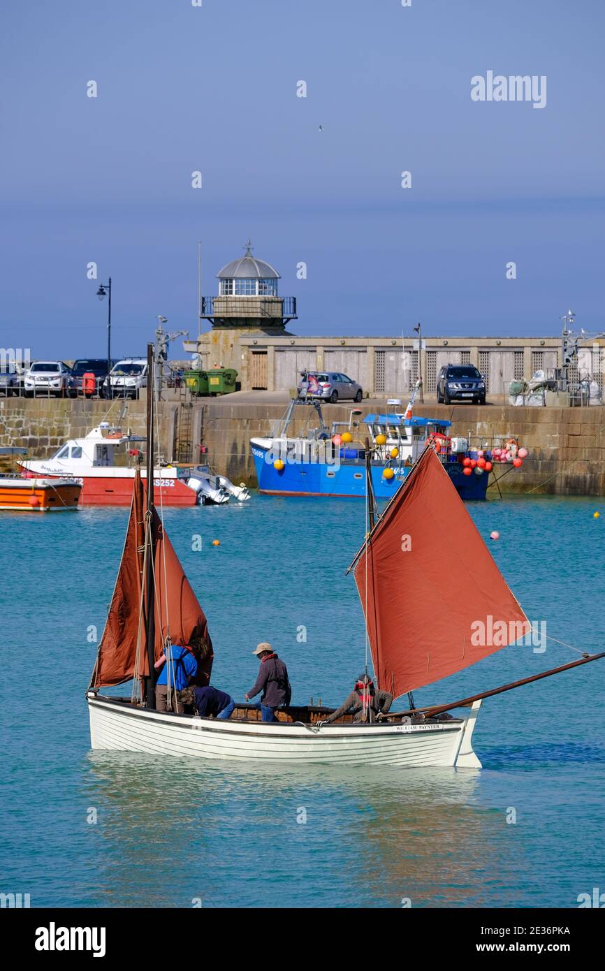 Traditional Cornish red sail boat in the harbout at St Ives in Cornwall ...