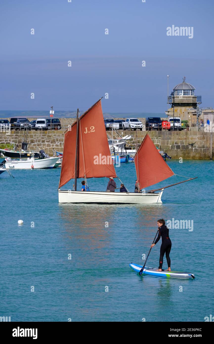 Traditional Cornish red sail boat in the harbout at St Ives in Cornwall ...