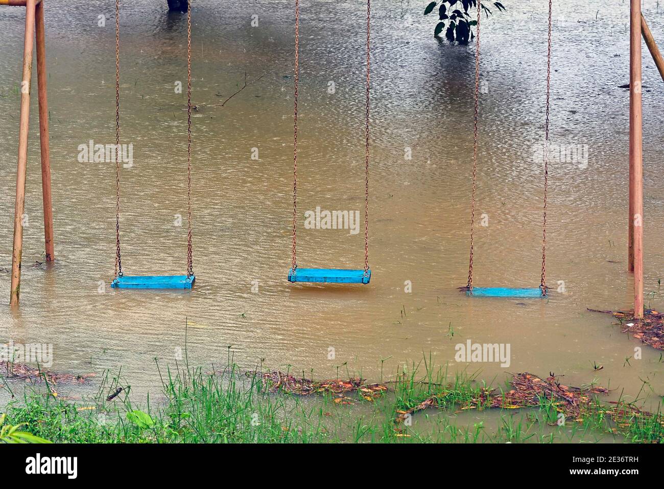Playground swings with flooded ground and grass underneath Stock Photo ...