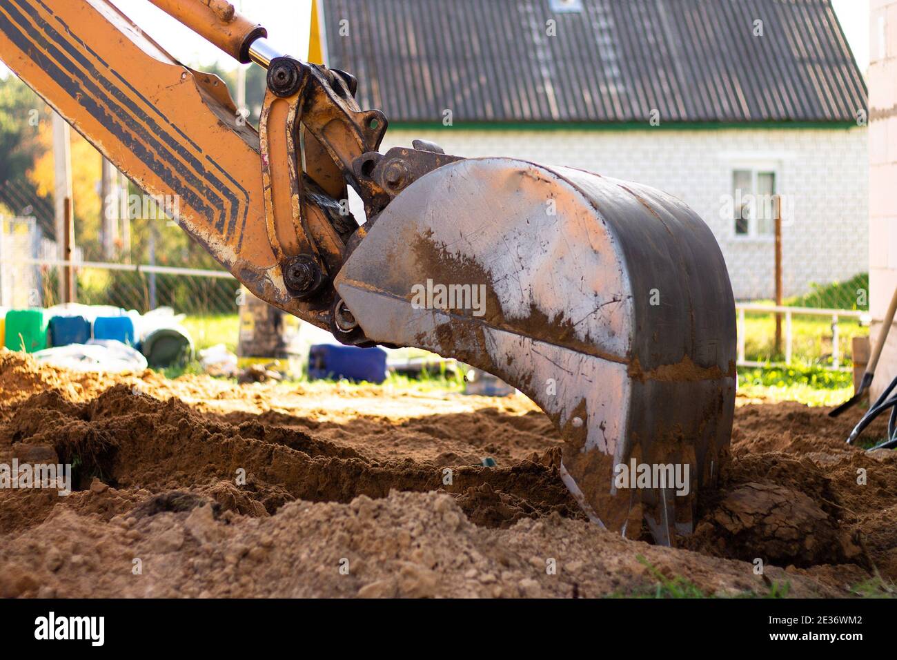 An excavator metal bucket digs sand or clay on a construction site ...