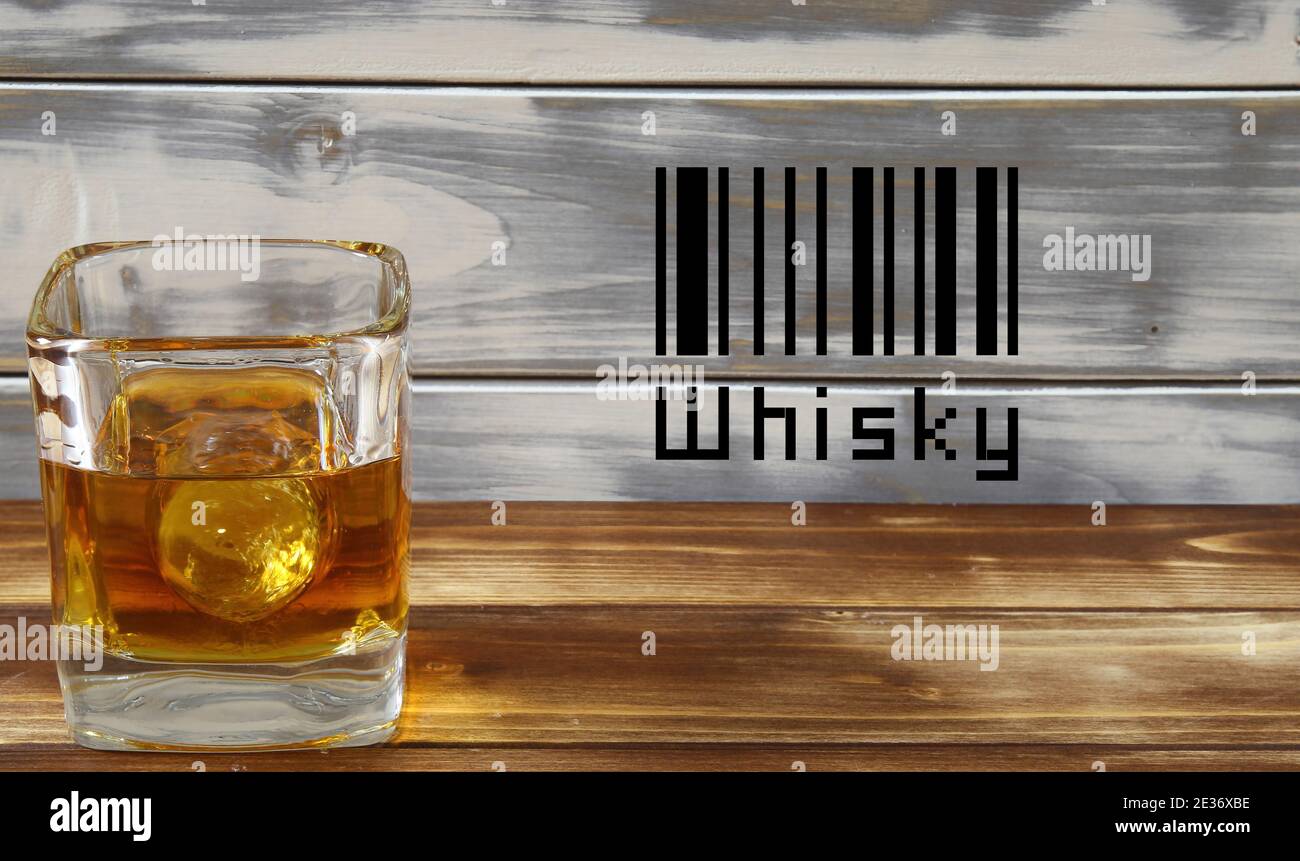 Close up of one isolated whisky glass with ice cube and timber wood ...