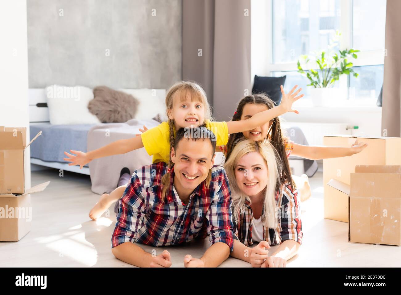 Happy family moving home with boxes around Stock Photo - Alamy