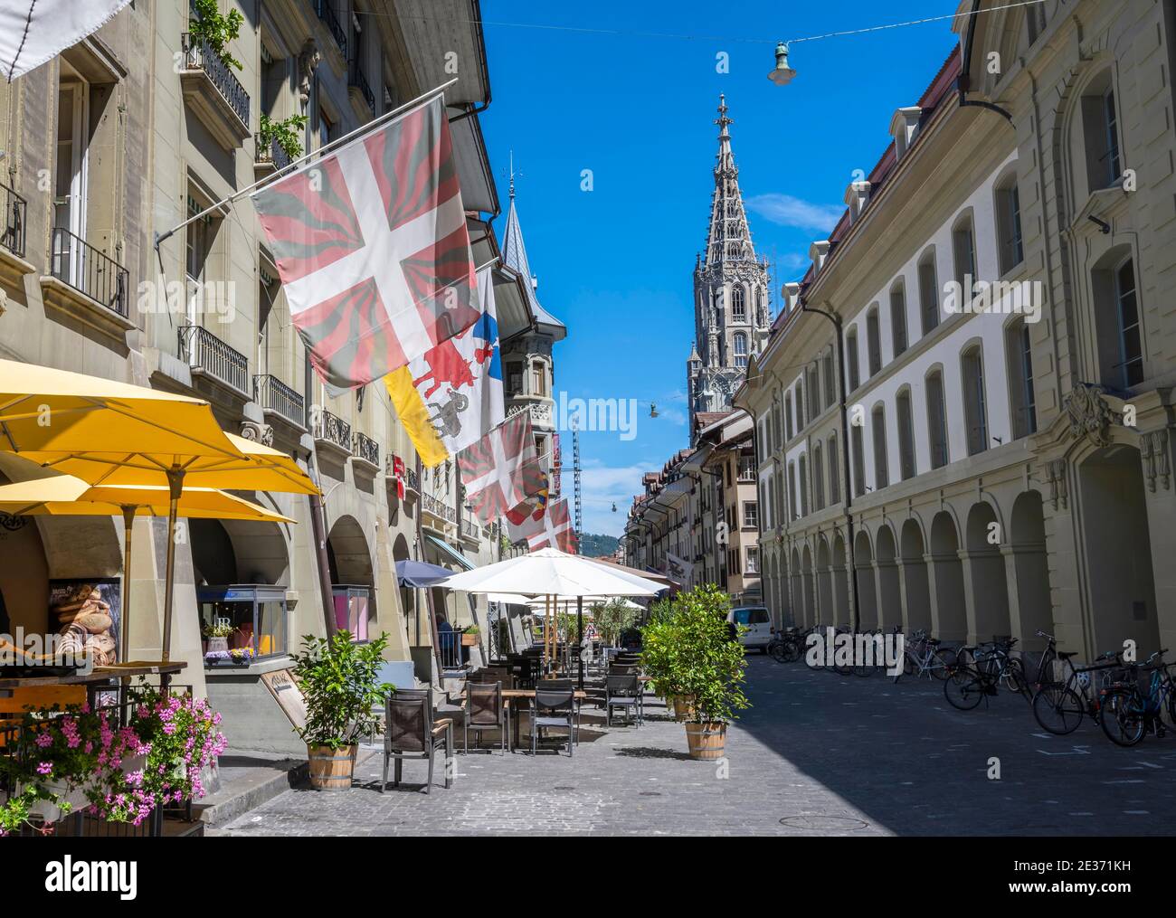 Flags on a row of houses in the old town of Bern, behind tower of the ...