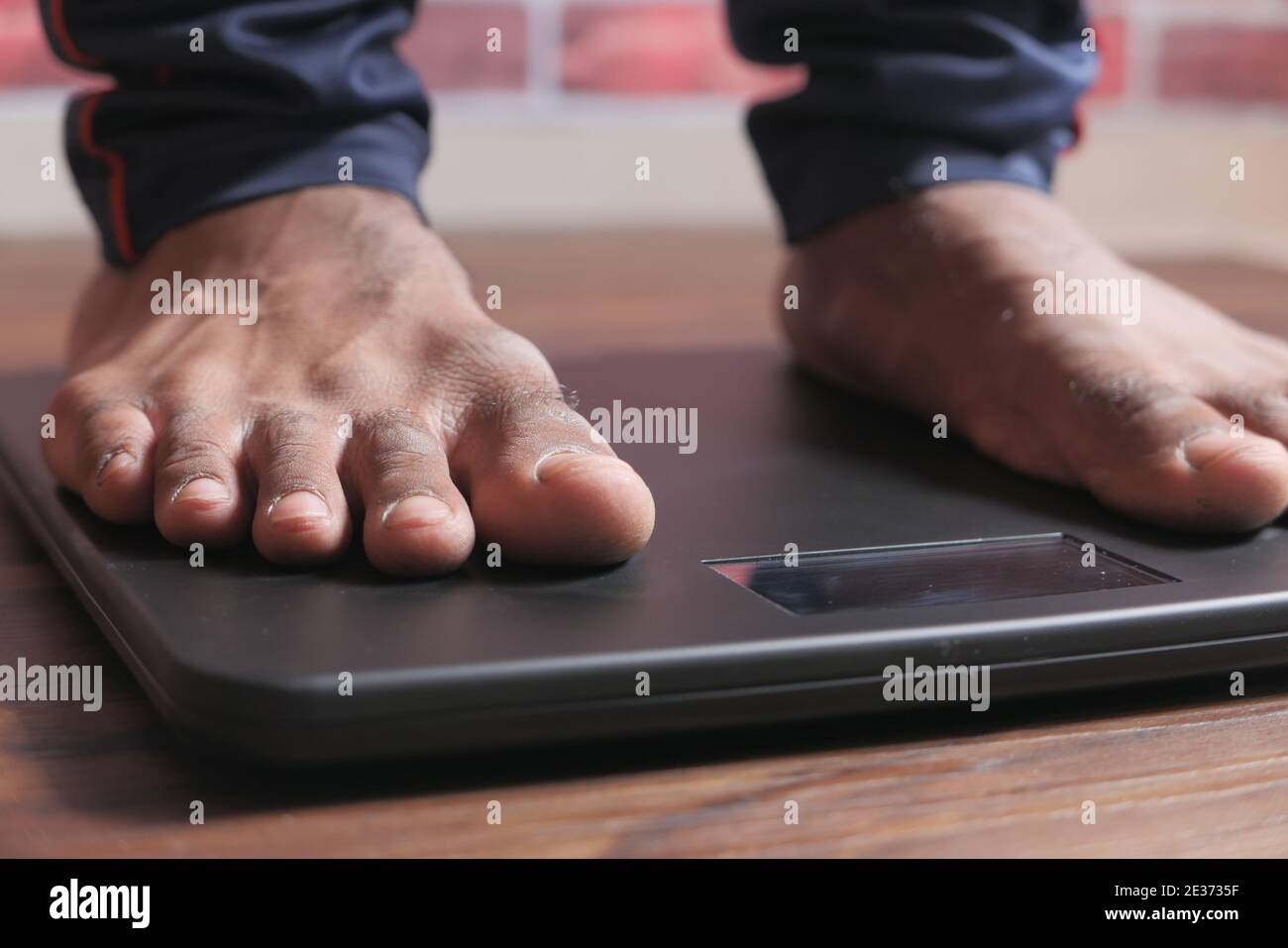 young man's feet on weight scale close up Stock Photo - Alamy