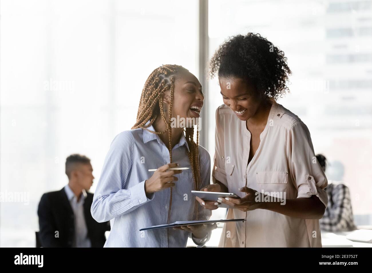 Happy multiracial female colleagues laugh brainstorming in office Stock ...