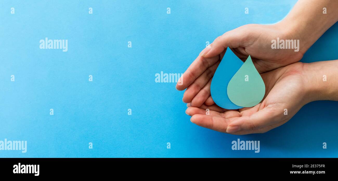 A view of woman hands holding paper cut water drops on a blue ...