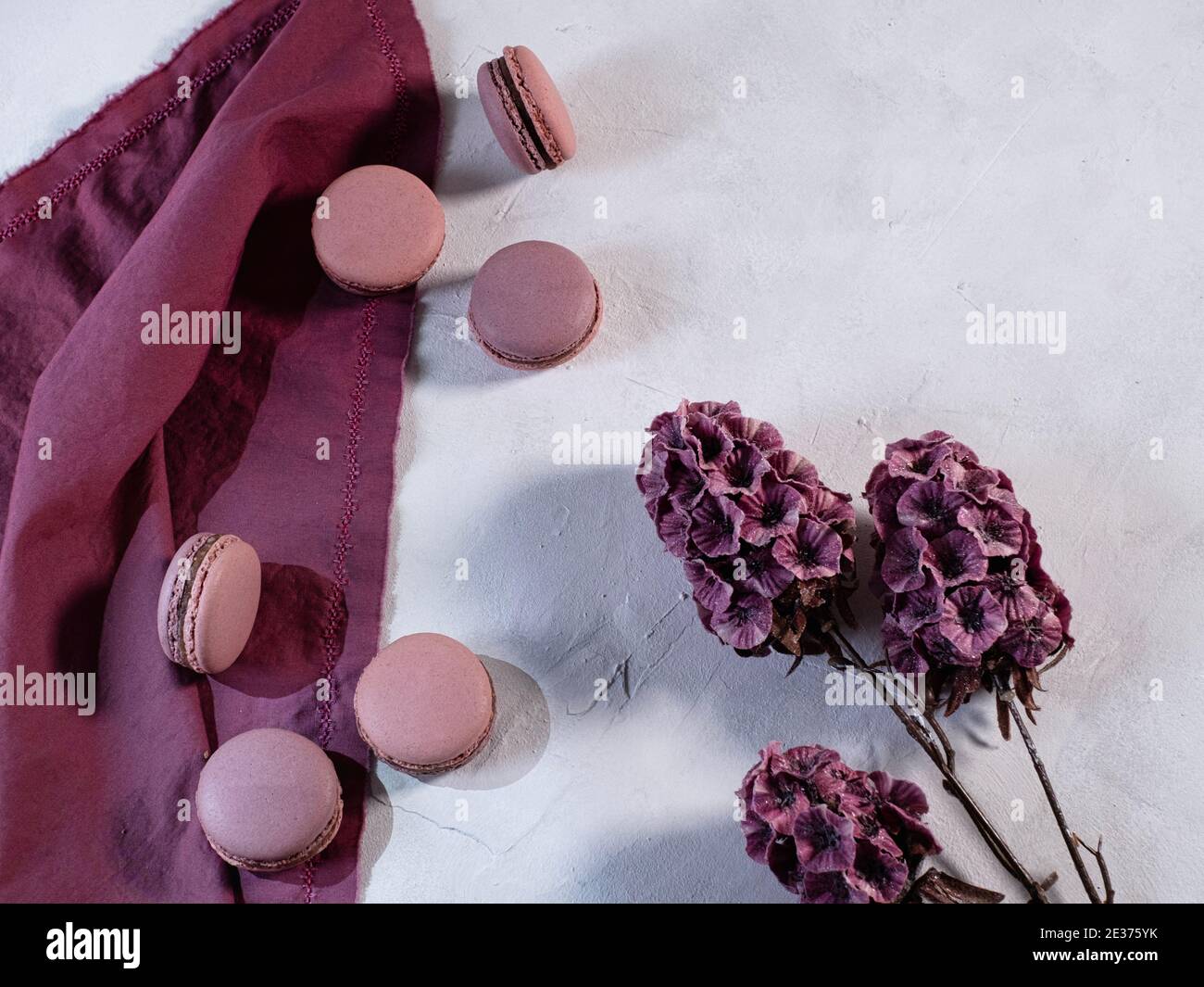Fig macarons on a white concrete background with plum blue napkin and a ...