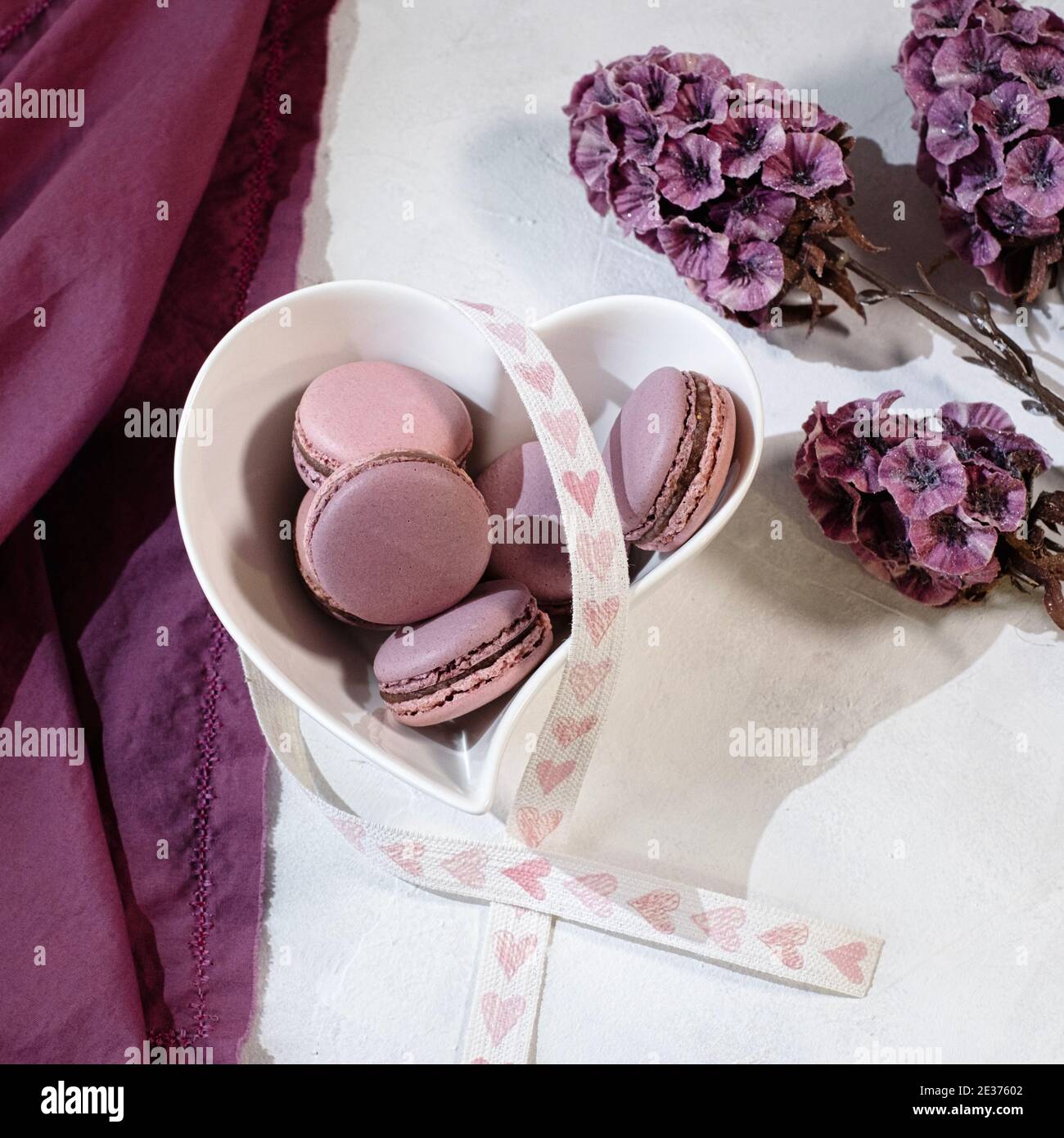 Fig macarons on a white concrete background with plum blue napkin and a ...
