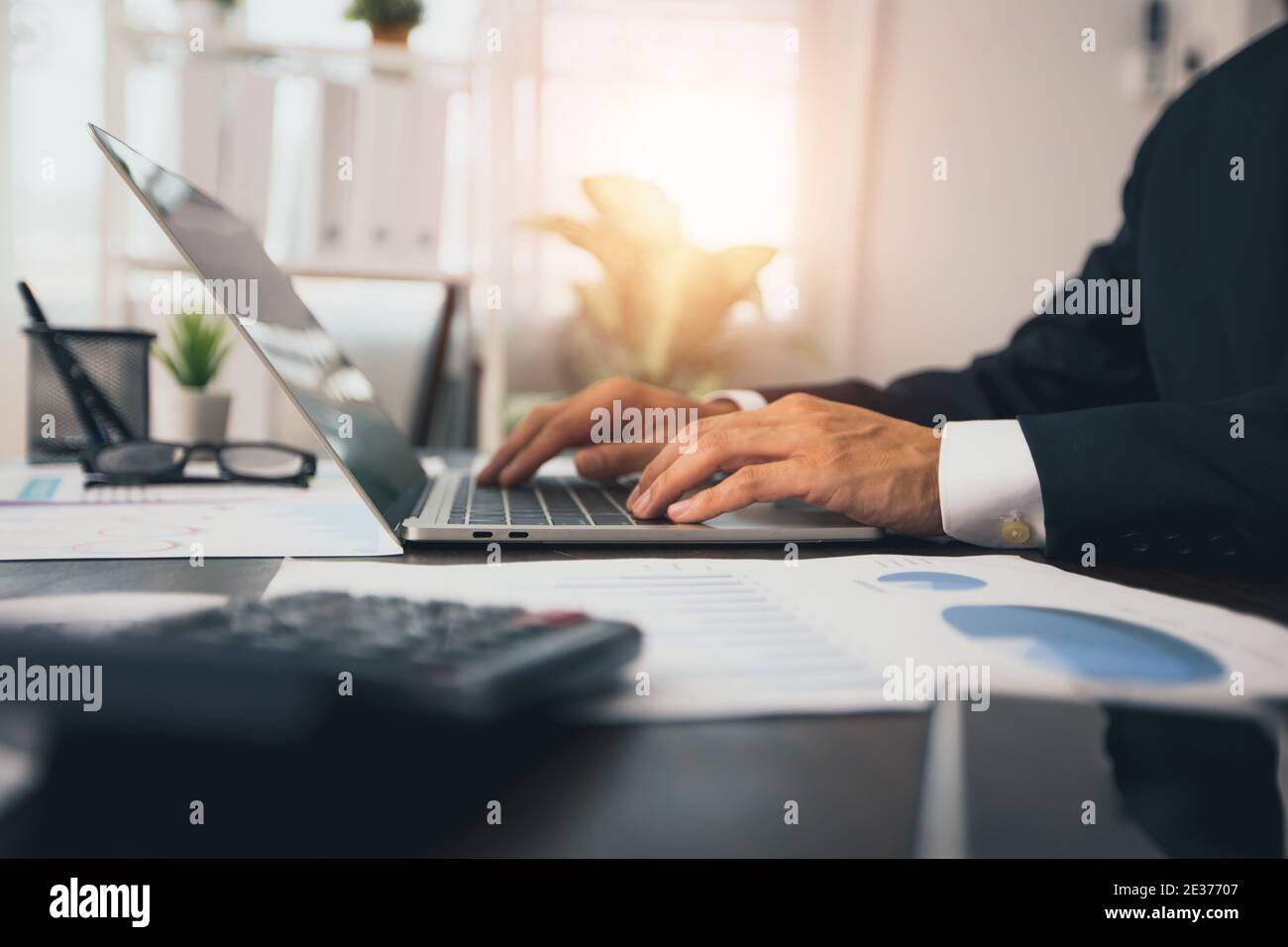 Close up hand of business man typing and working on laptop with finance ...