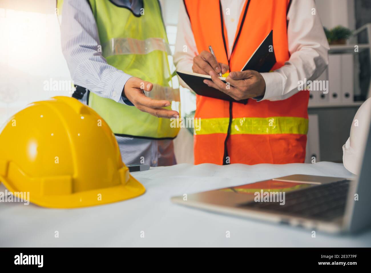 close up helmet of engineer explaining project work on laptop and ...