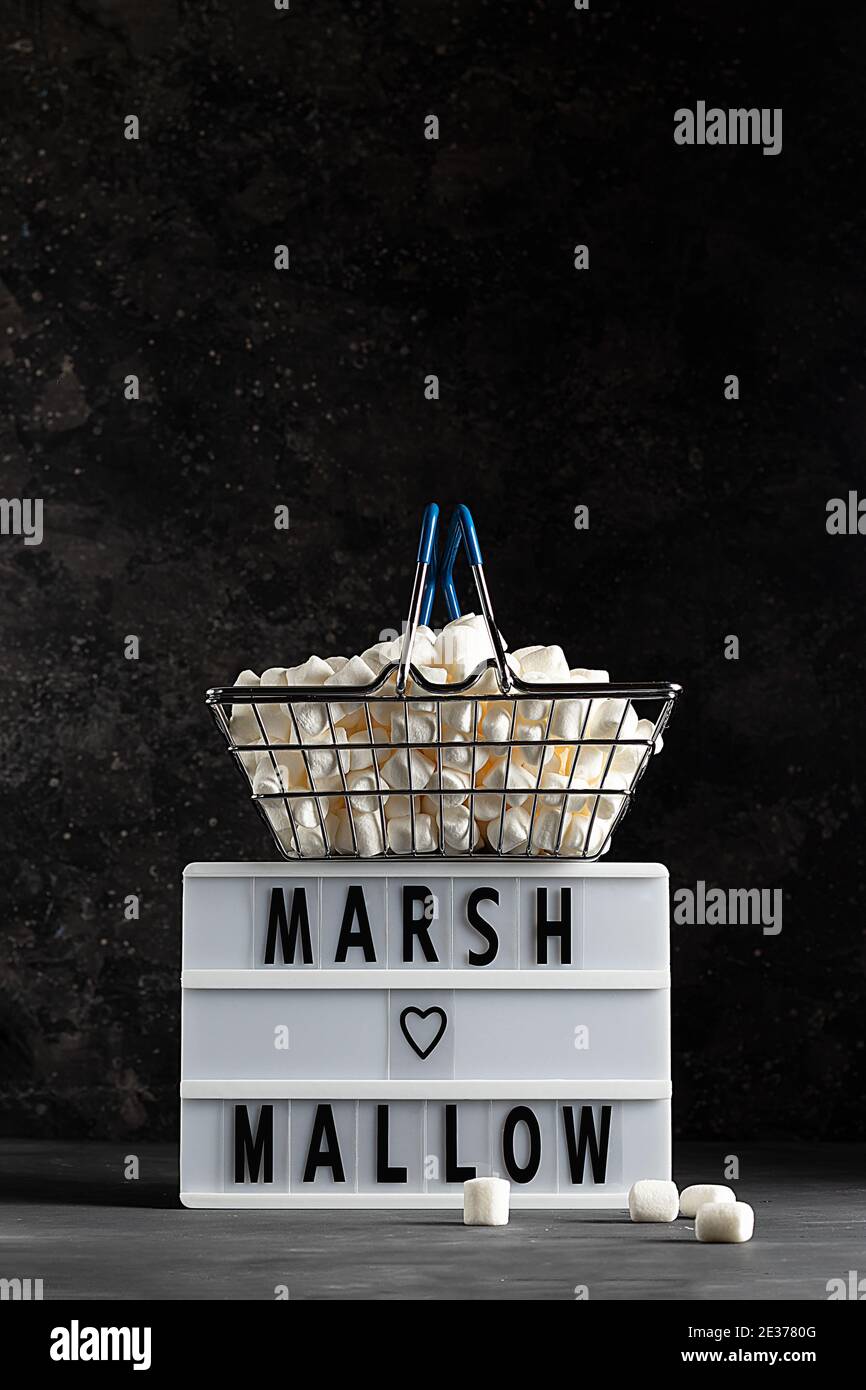White airy marshmallows in metal grocery basket on chalkboard with ...
