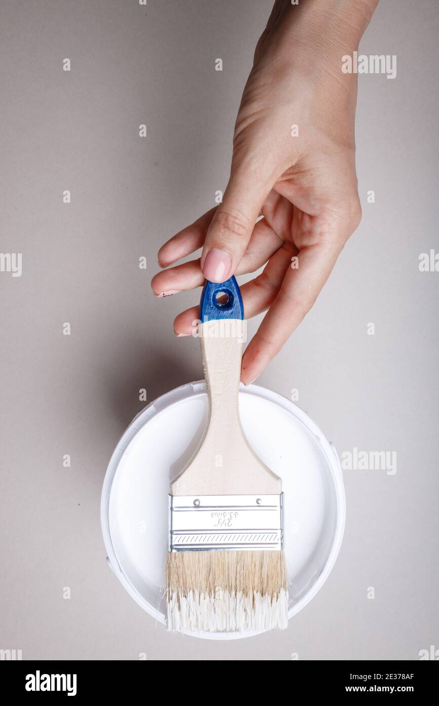 Brush in white paint in hand Stock Photo - Alamy