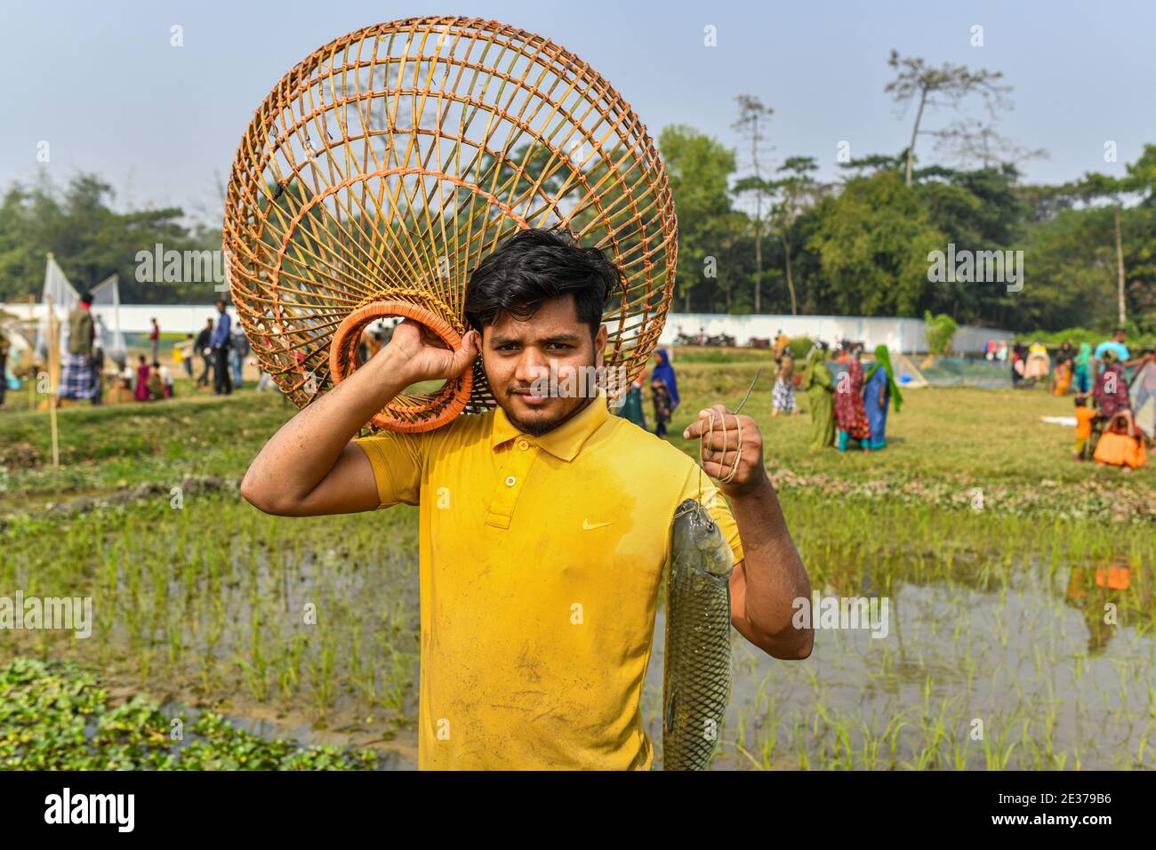 Sylhet, Bangladesh. 16th Jan, 2021. A man seen holding a fish and a ...