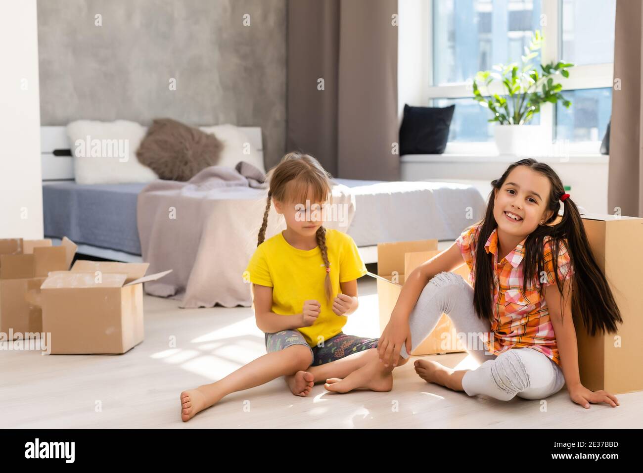 Excited funny kids girls running inside luxury big modern house on ...