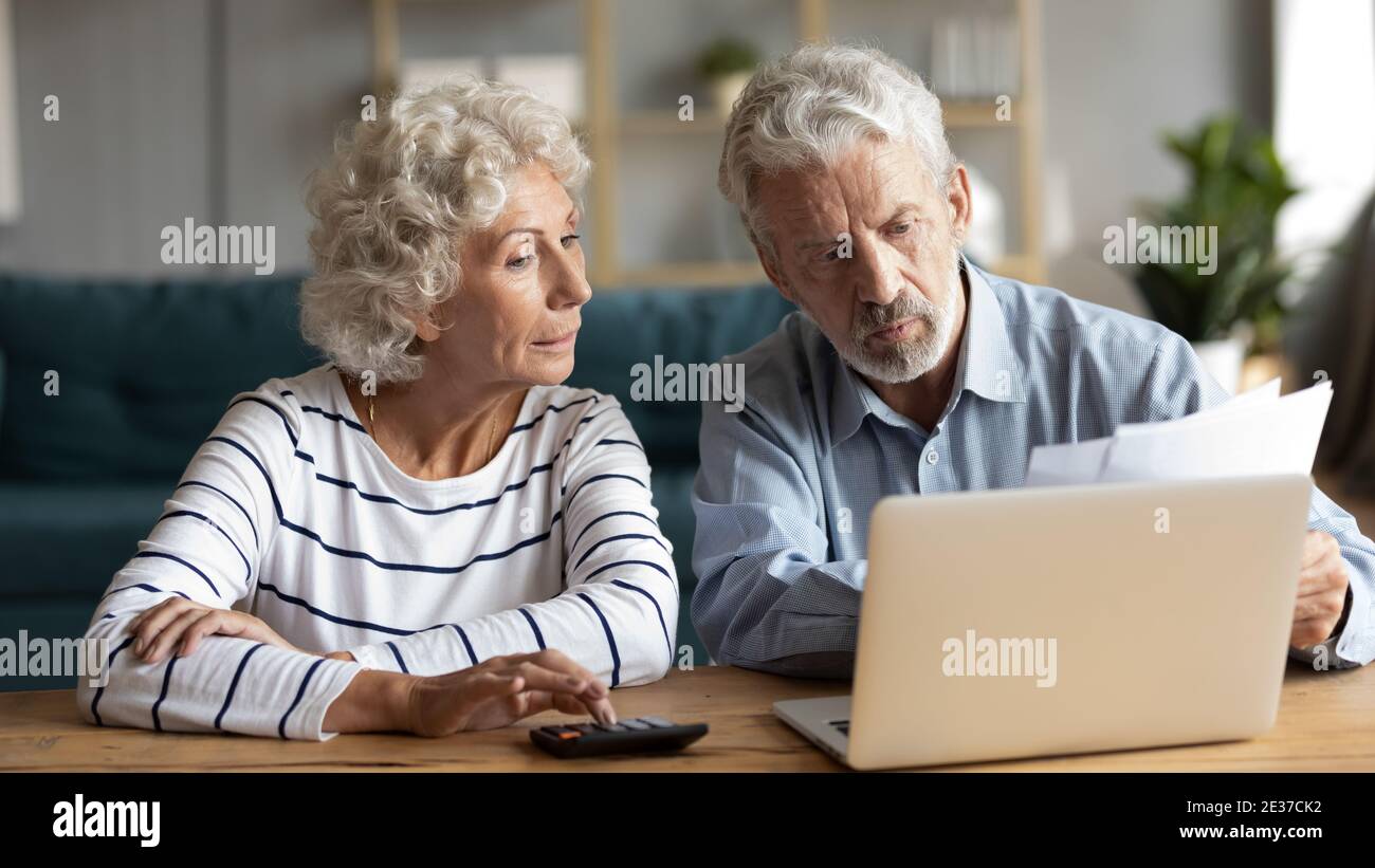 Focused Middle Aged Retired Family Couple Managing Monthly Budget Stock focused-middle-aged-retired-family-couple-managing-monthly-budget-stock