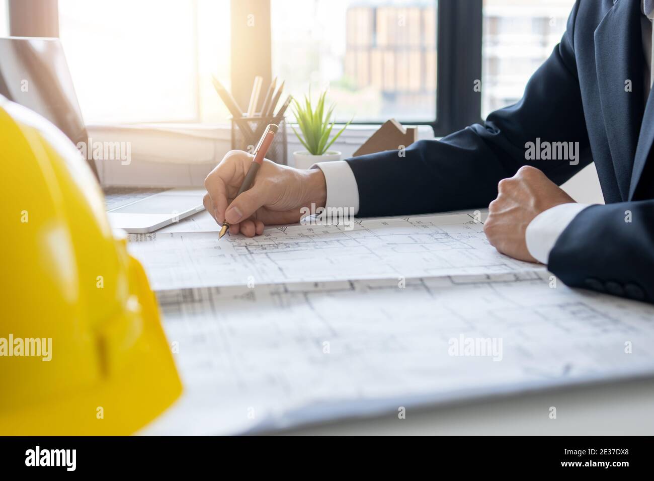 architect drawing and make construction plan on blueprint in office ...