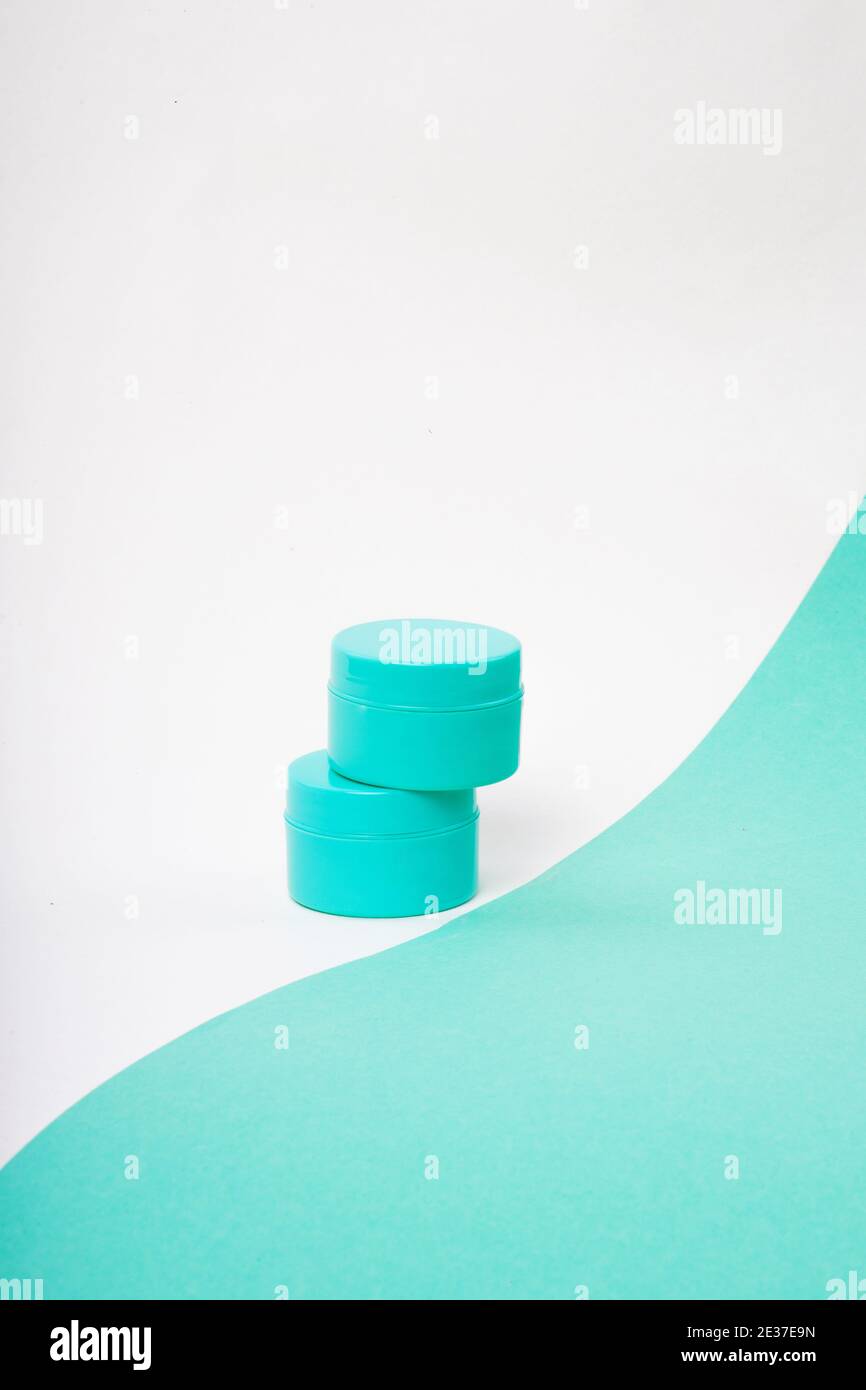 Two containers of mint color on a mint white background Stock Photo - Alamy
