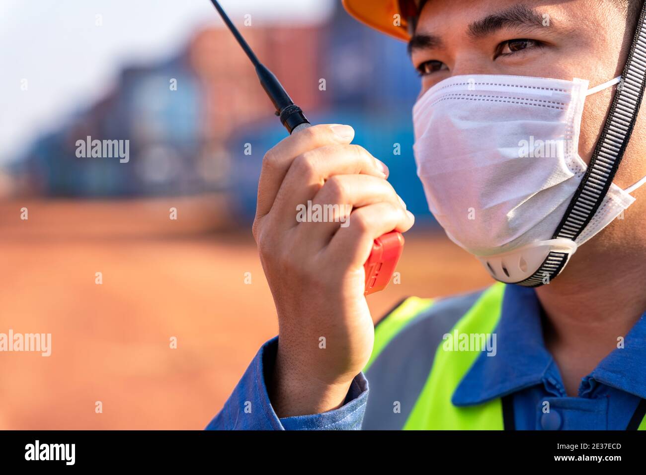 Close up foreman worker wear a mask working use a long distance radio ...