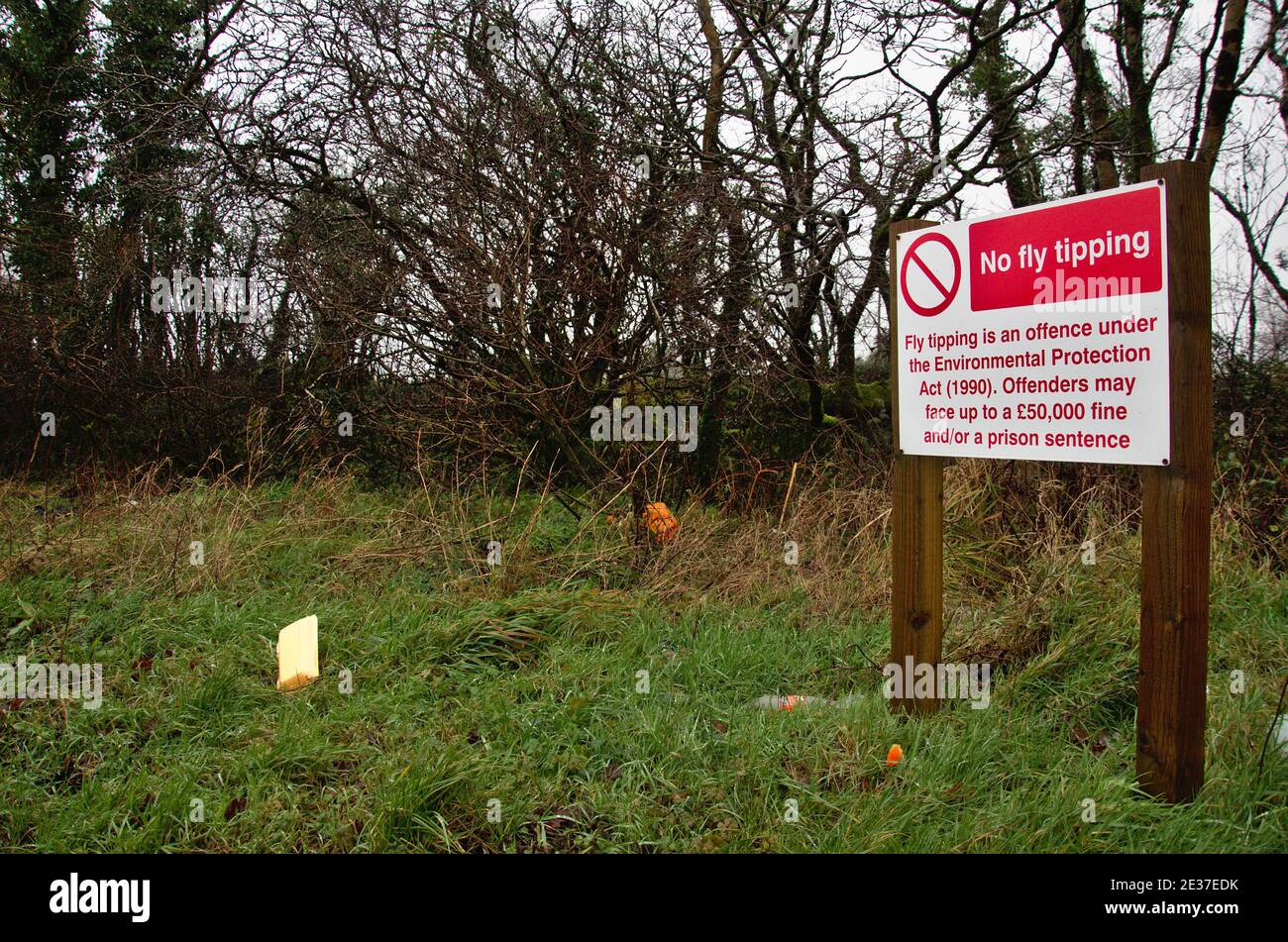 No fly tipping sign on a road side lay by, with some littering evident ...