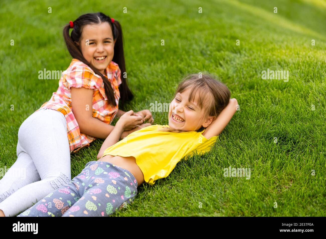 Portrait of two little girls sisters fighting on home backyard. Friends ...