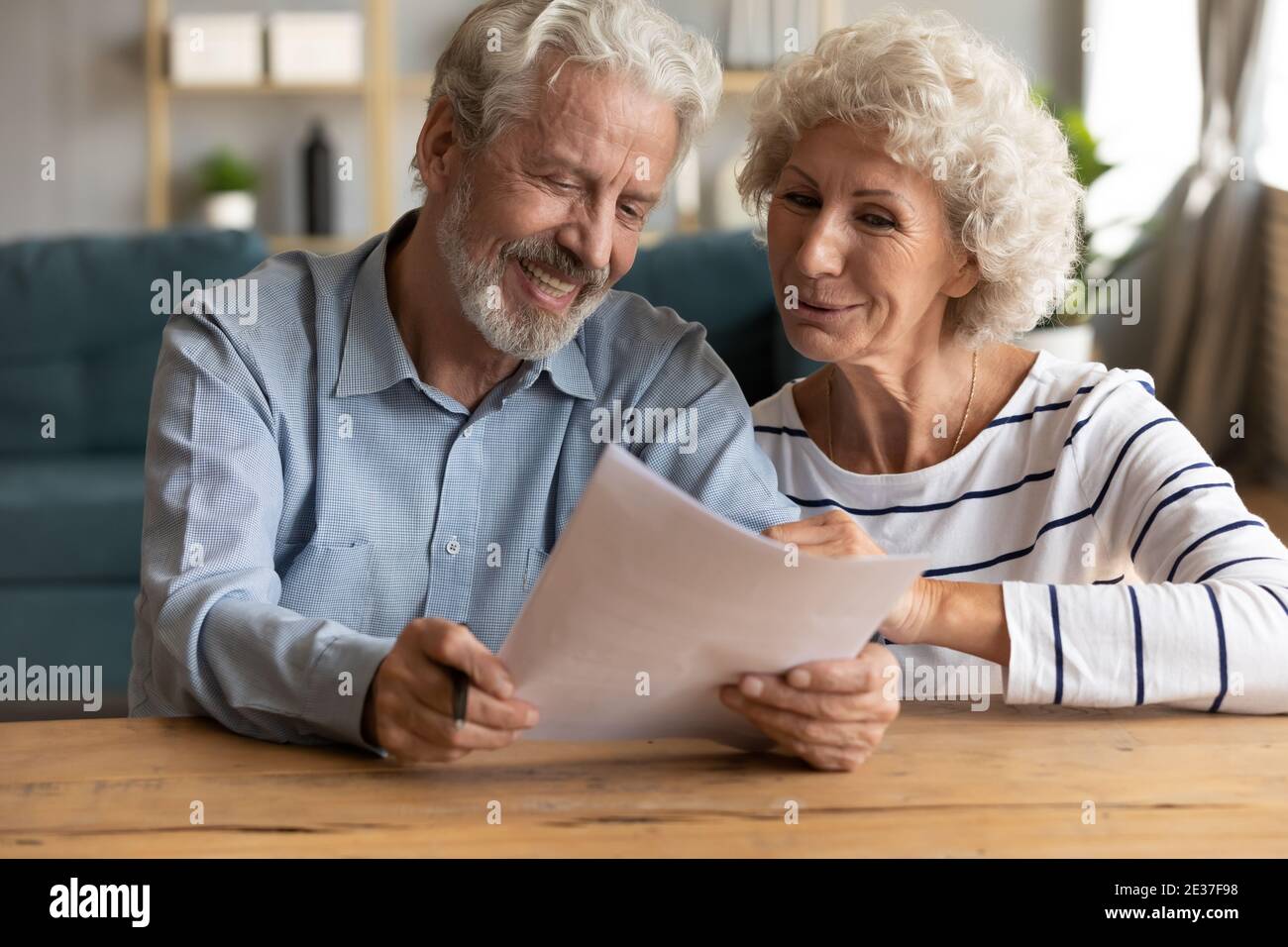 Happy senior family couple reading paper document Stock Photo - Alamy
