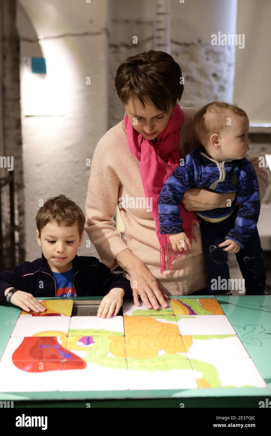 Family playing with puzzle in a museum Stock Photo - Alamy
