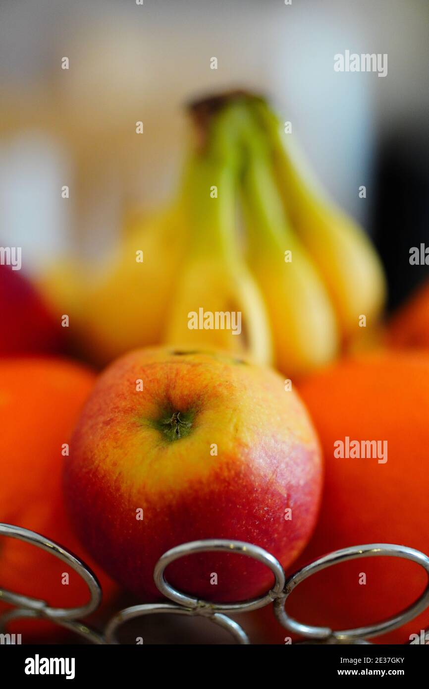 A vertical shot of a colorful and tasty apple with some fruits in a ...