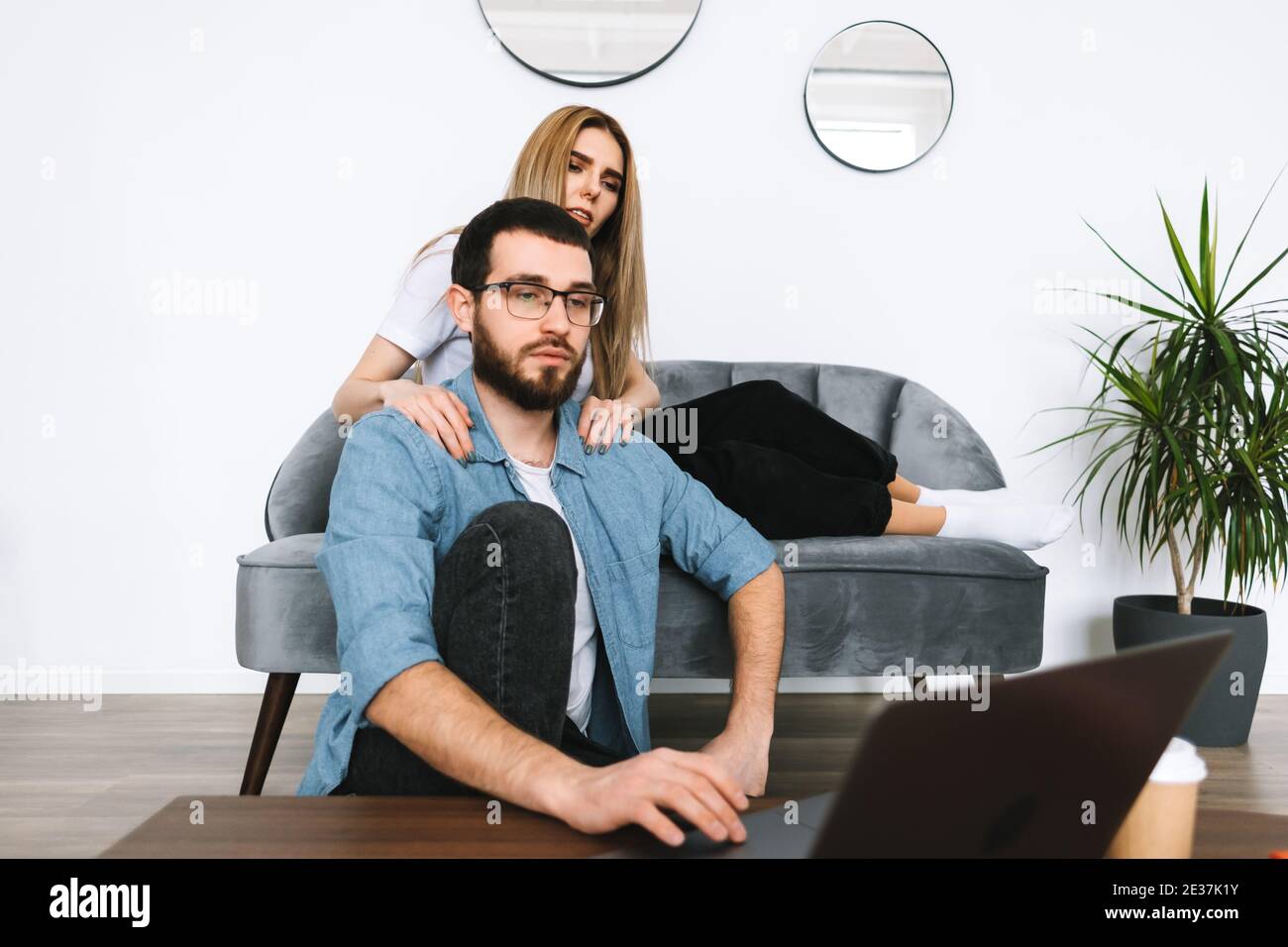 Young couple using laptop computer, browsing information and looking at ...