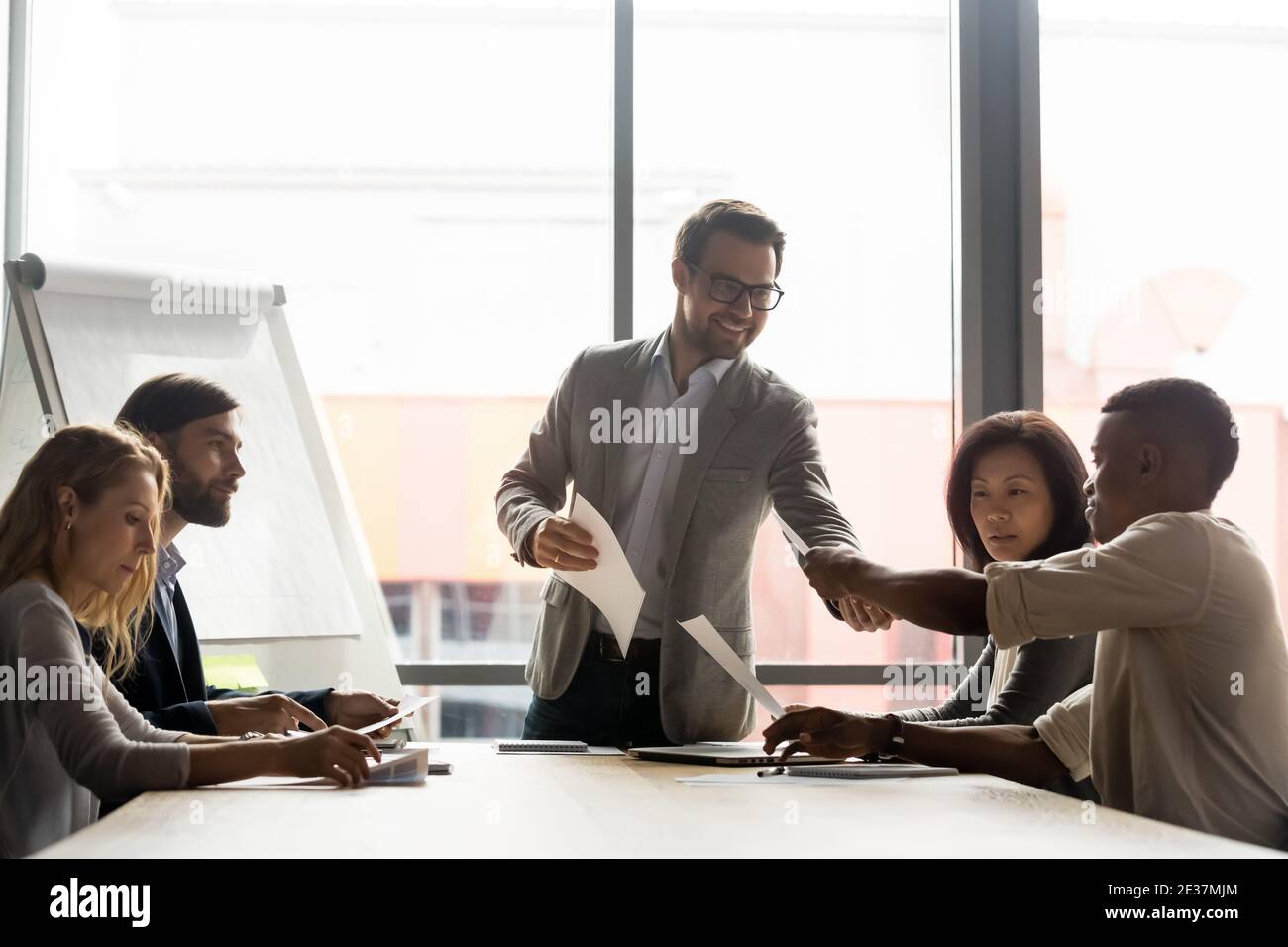 Smiling young male ceo executive manager analyzing data with colleagues ...