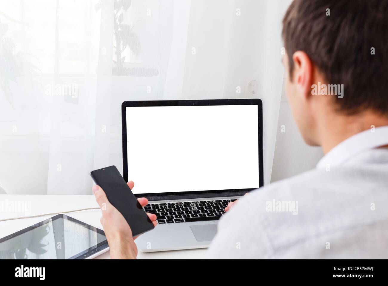 Back view of male person sitting front open laptop computer with blank ...