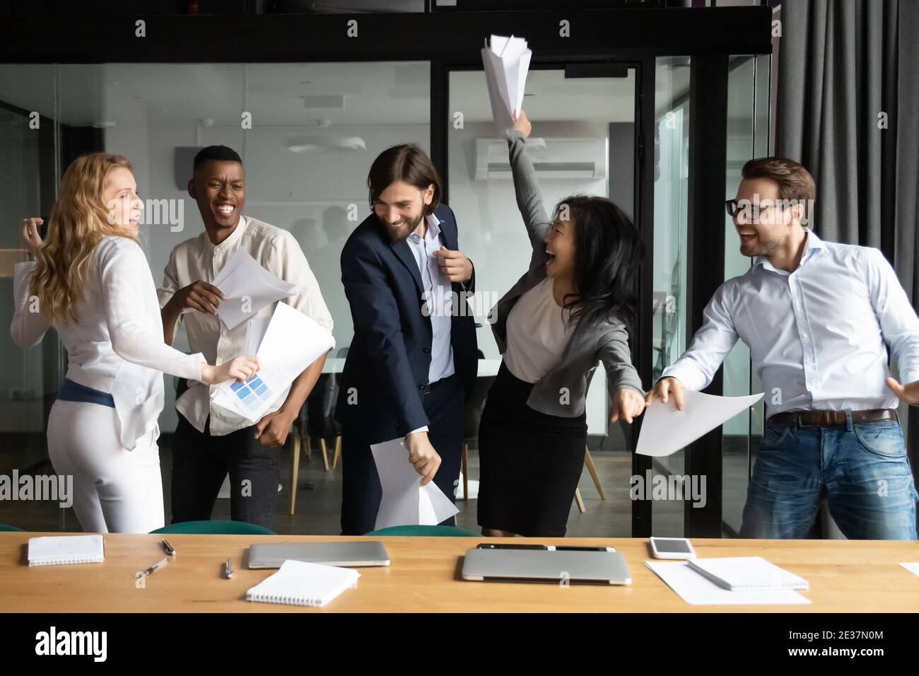 Overjoyed happy young and senior multiracial business people having fun ...