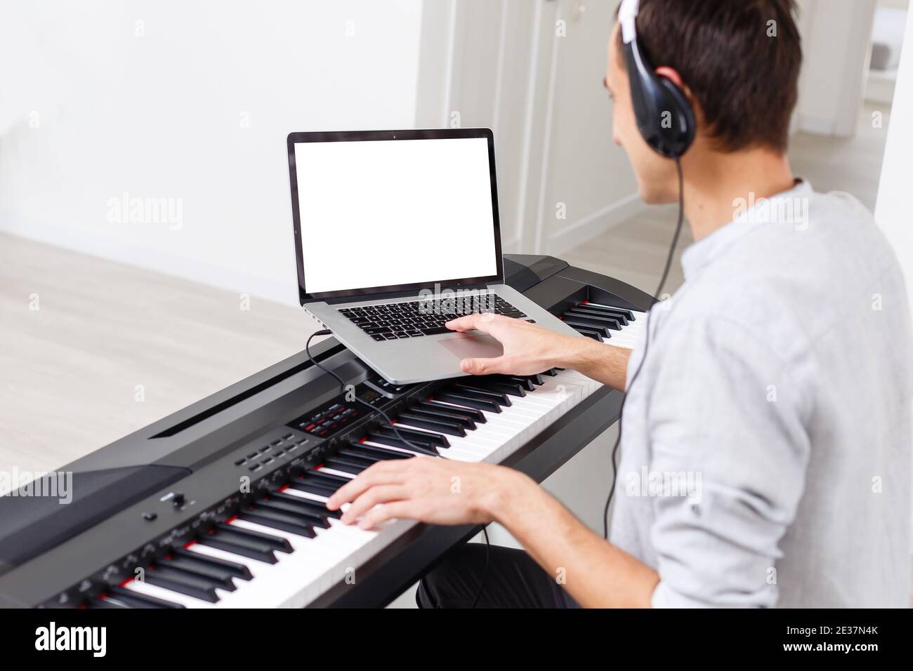 male composer hands using computer, midi keyboard & studio equipment ...