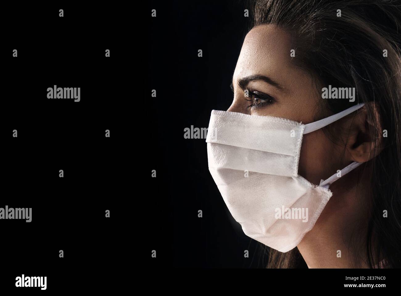 Closeup portrait of a brunette woman wearing a hygienic, reusable mask ...