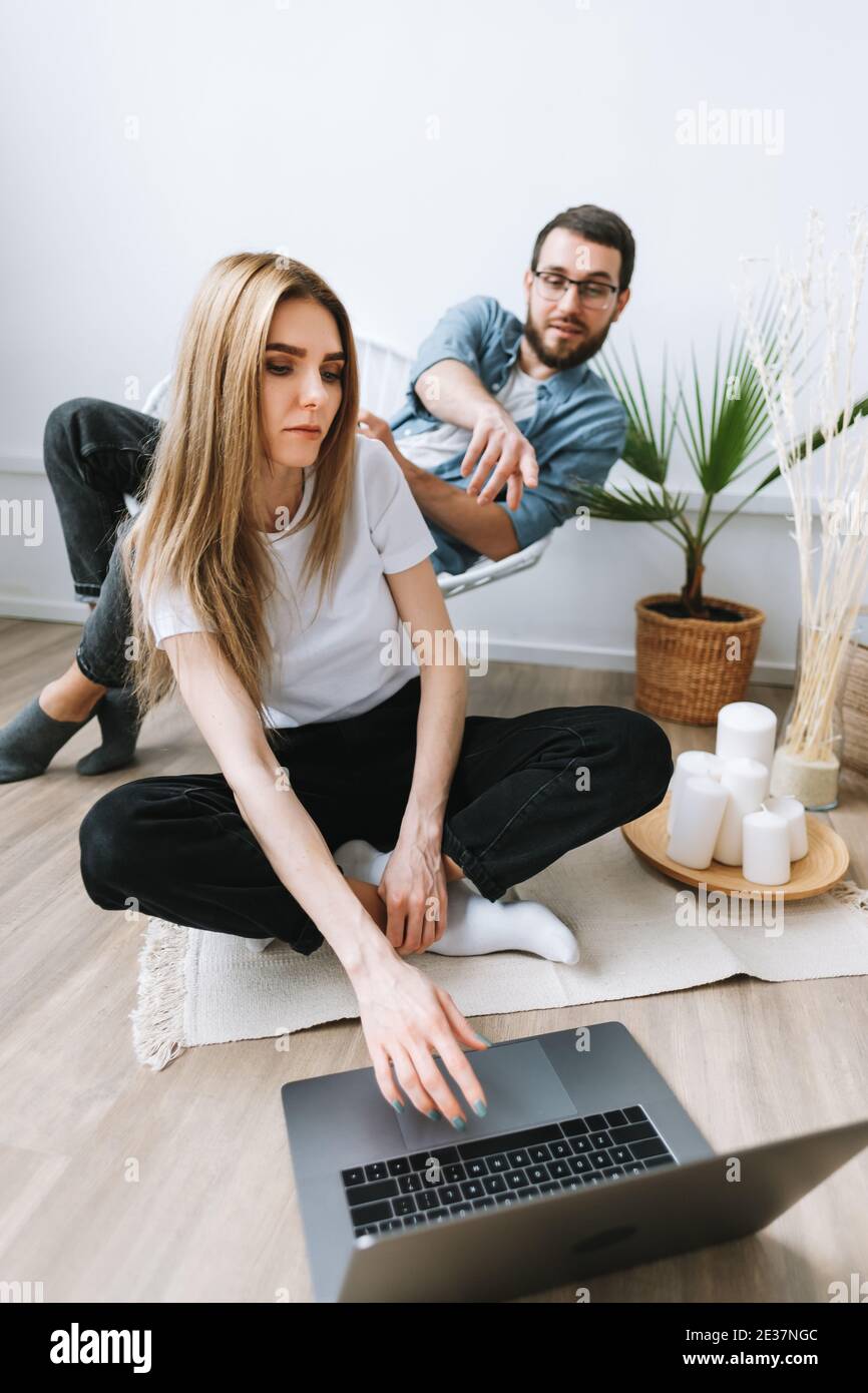 Young couple using laptop computer, browsing information and looking at ...