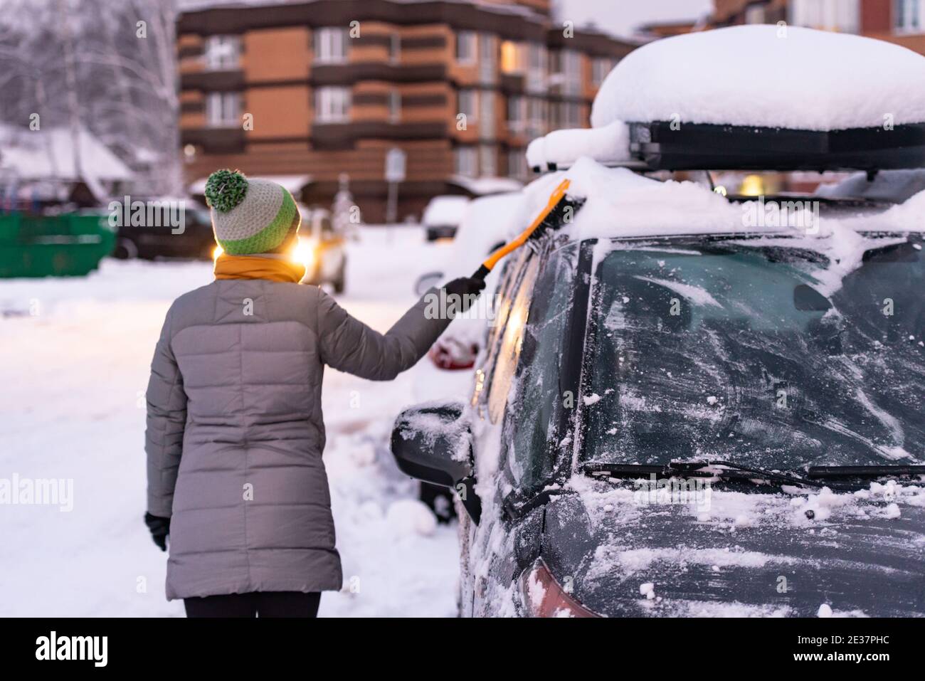 Moscow. Russia. Winter 2020. The driver clears the car of snow. During ...