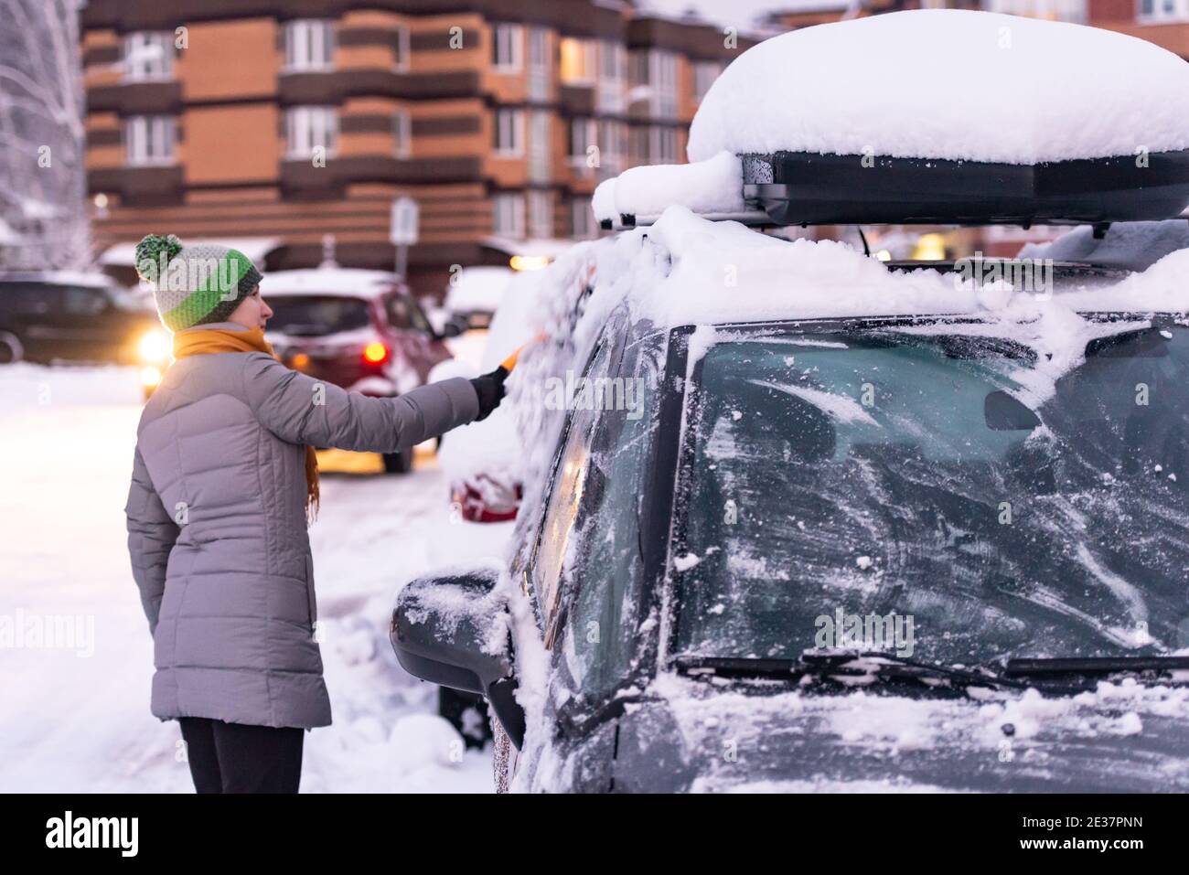 Moscow. Russia. Winter 2020. The driver clears the car of snow. During ...