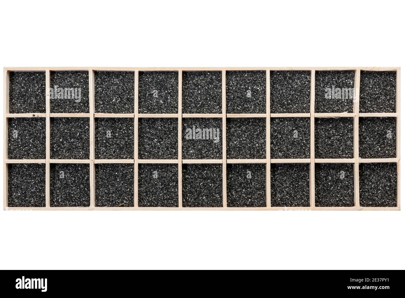 Black decorative sand distributed in a rectangular wooden box with ...